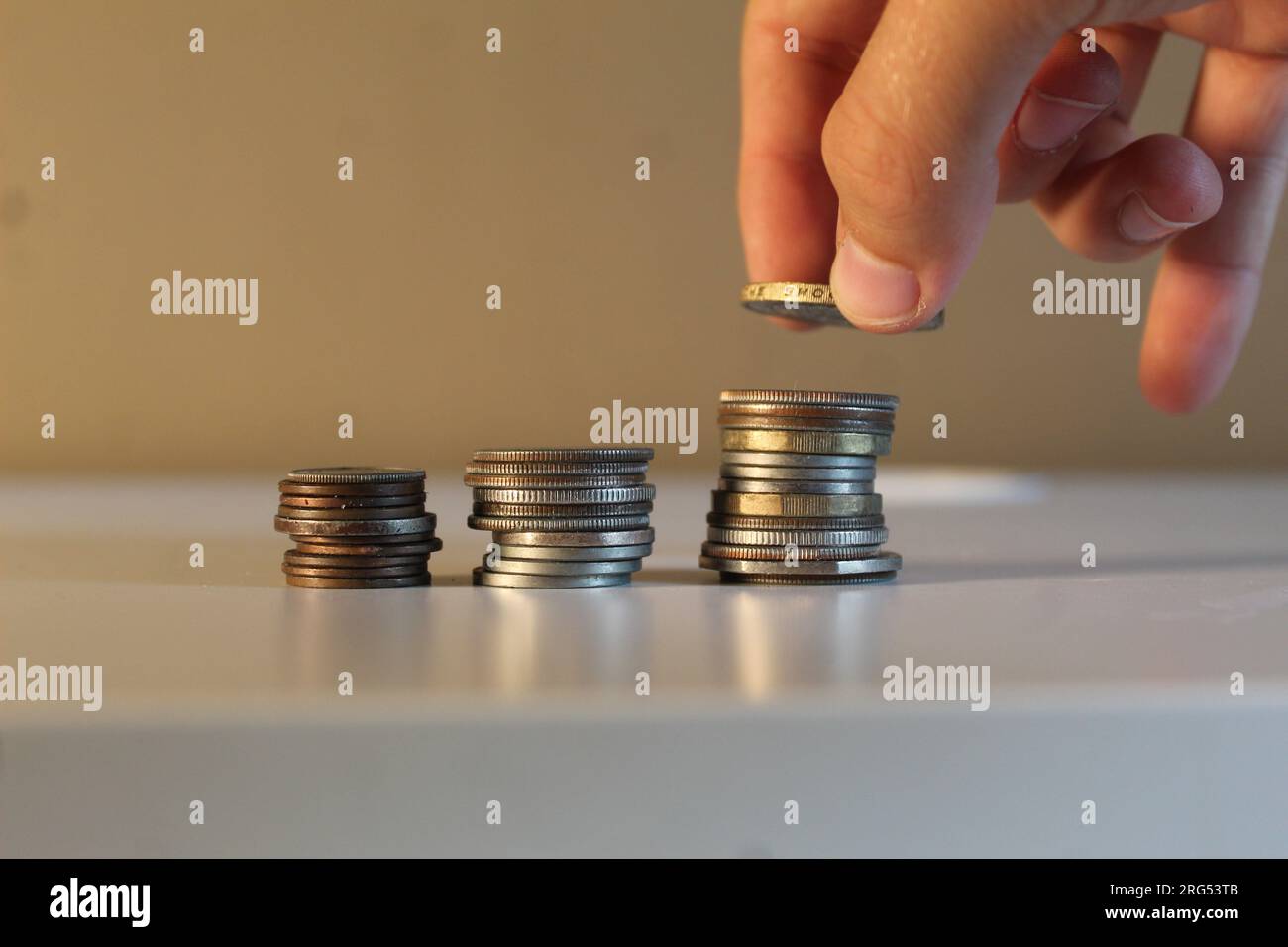 A photo of a person stacking coins on a desk Stock Photo - Alamy