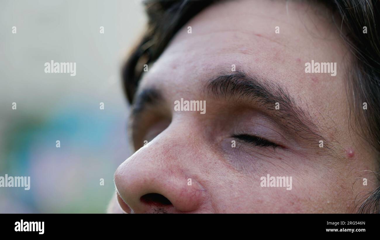 Person closing eyes in contemplation and then opens eye upwards to sky ...