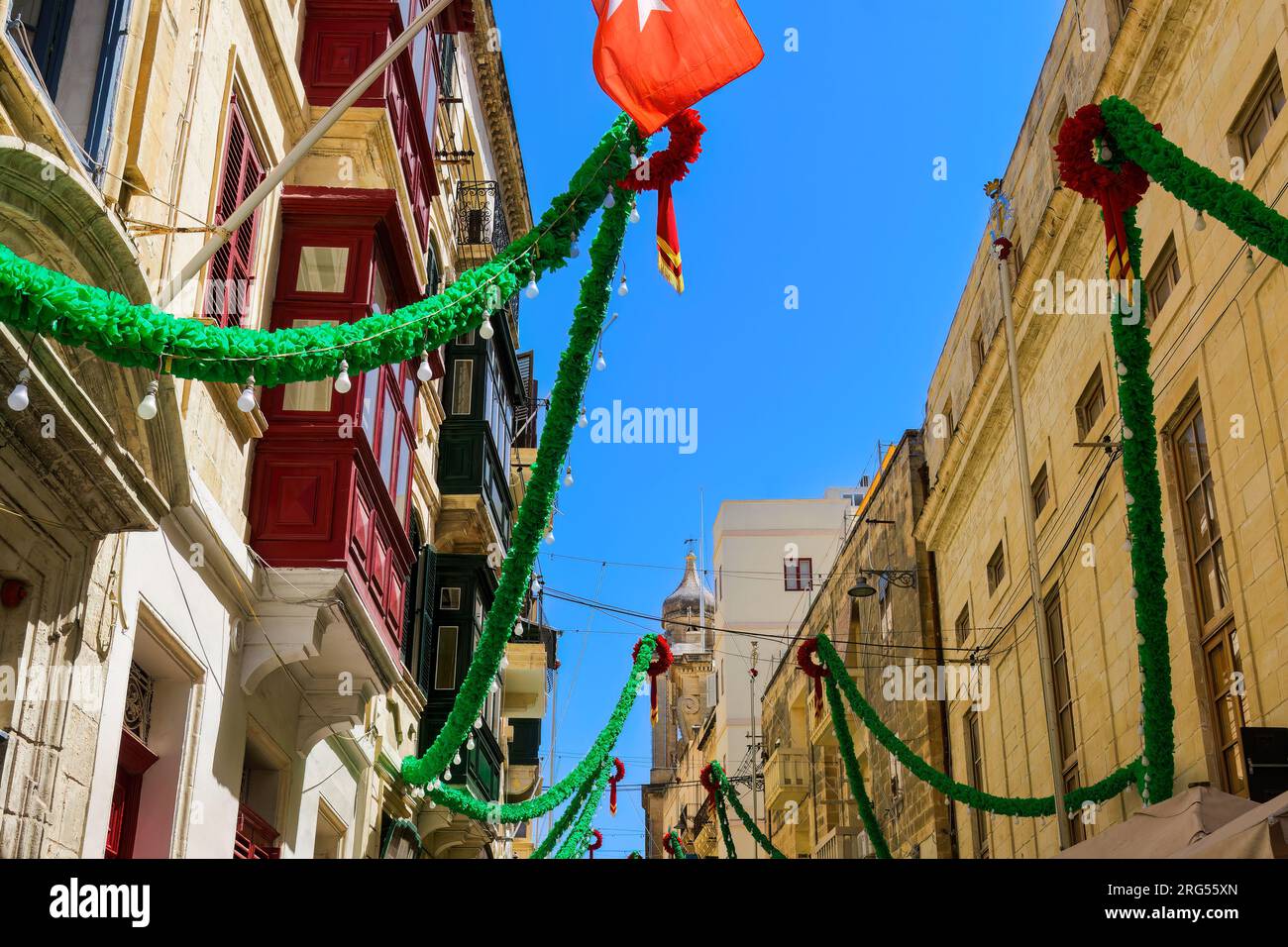 Traditional Maltese limestone buildings with hanging decorations around ...