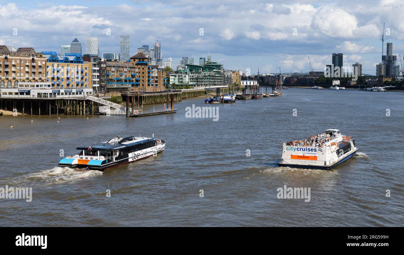 London, UK - July 29, 2023; Two passenger river boats travelling east ...