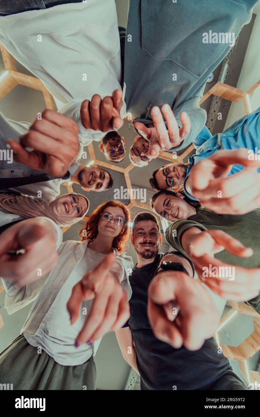 In a modern office, a group of young business professionals is captured ...