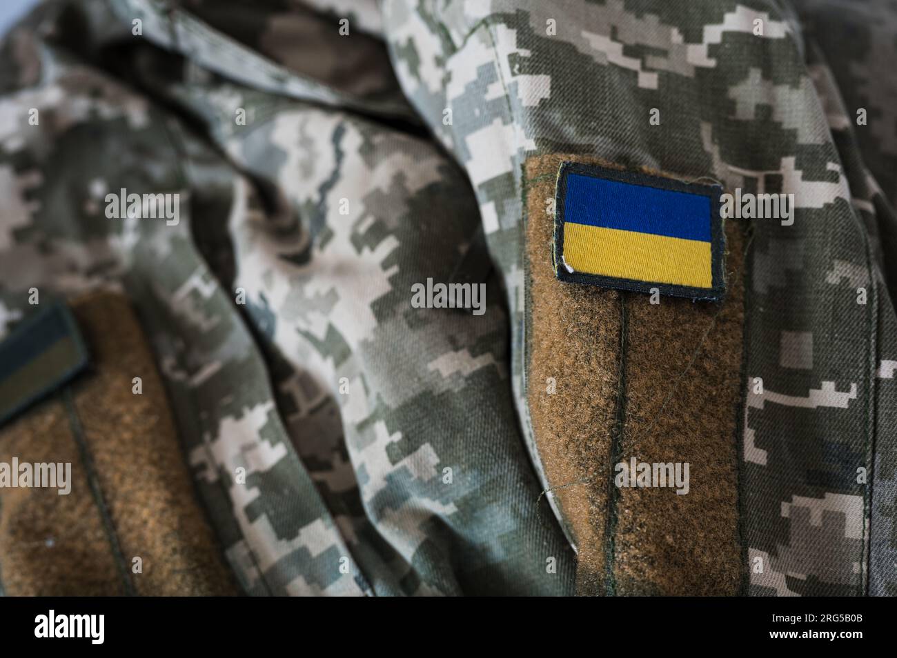 A banner of the Ukrainian flag on a soldier's pixel camouflage uniform ...