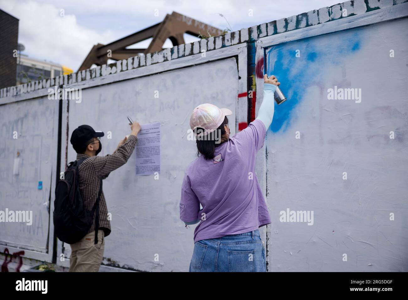 An anti-Chinese government activist seen painting the wall at Brick ...