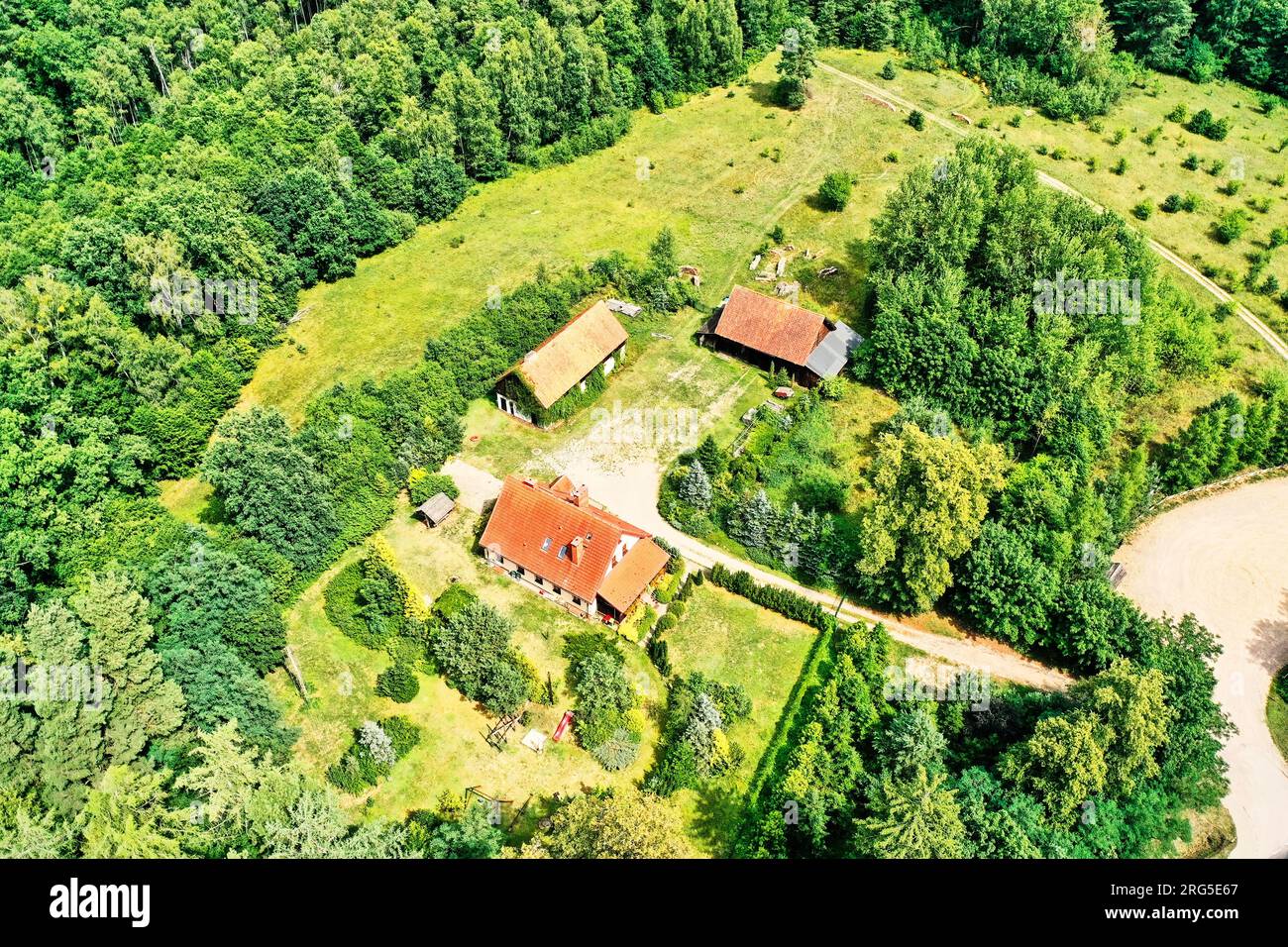 Aerial view of a farm surrounded by meadows in Poland in a forest area ...