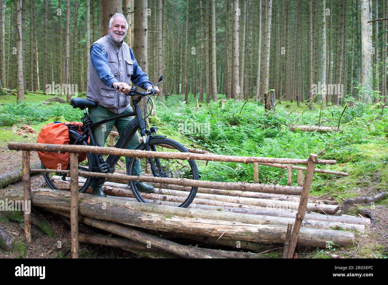 Deep in the forest, away from the bike paths, a senior pushes his bike ...