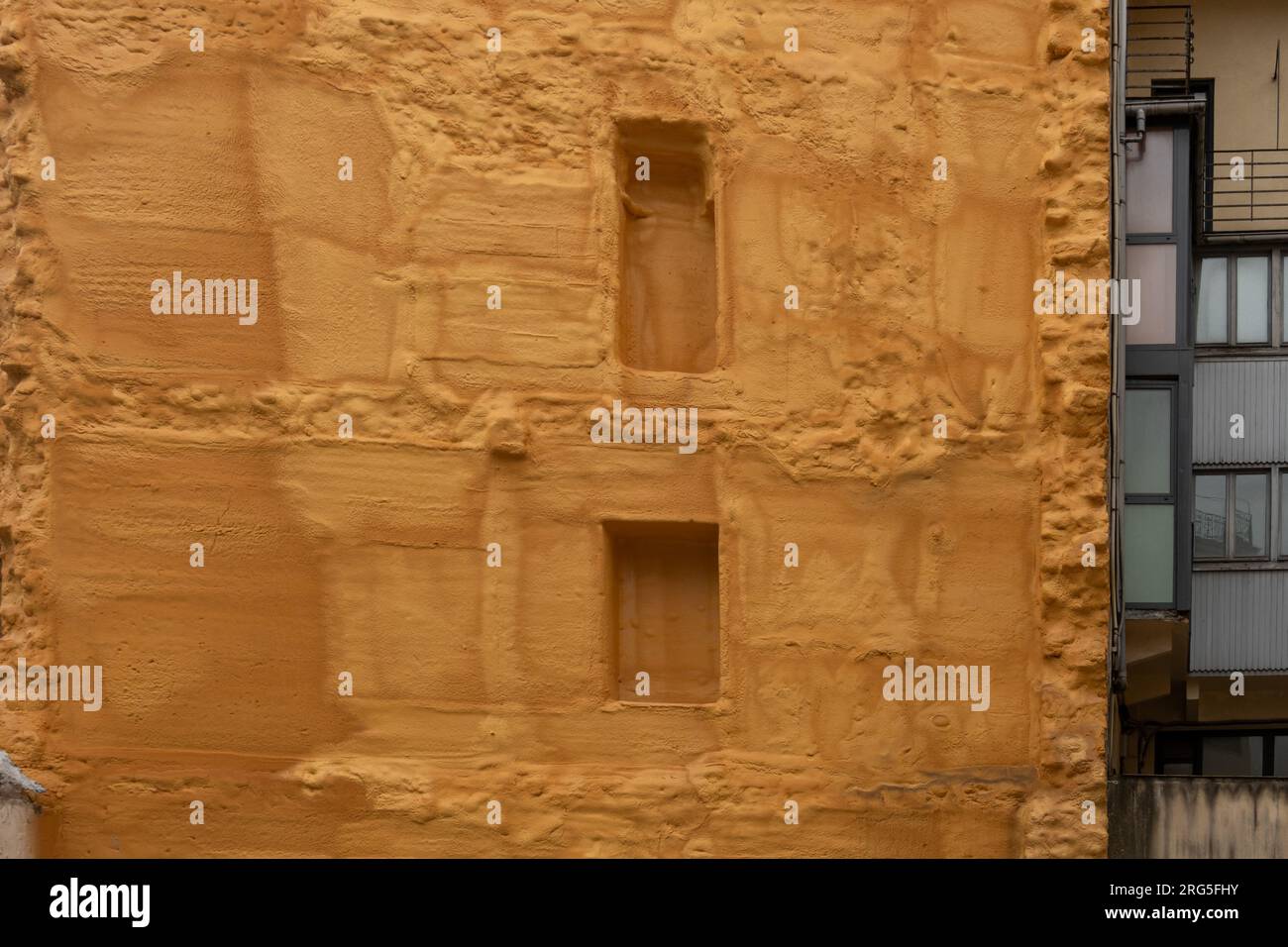 Yellow render sprayed on wall of existing building adjoining the site ...