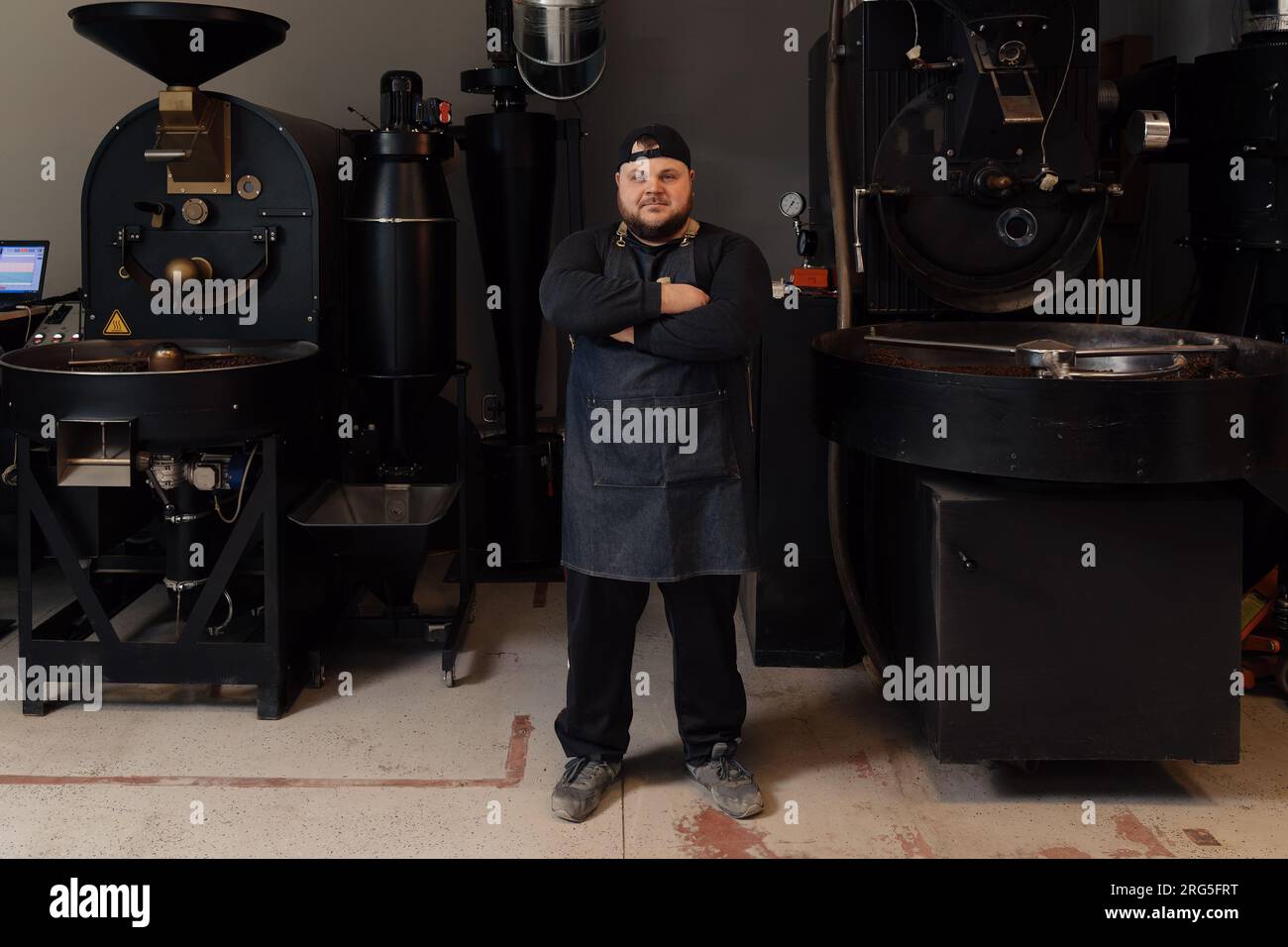 Male worker standing near professional roasting machine Stock Photo - Alamy