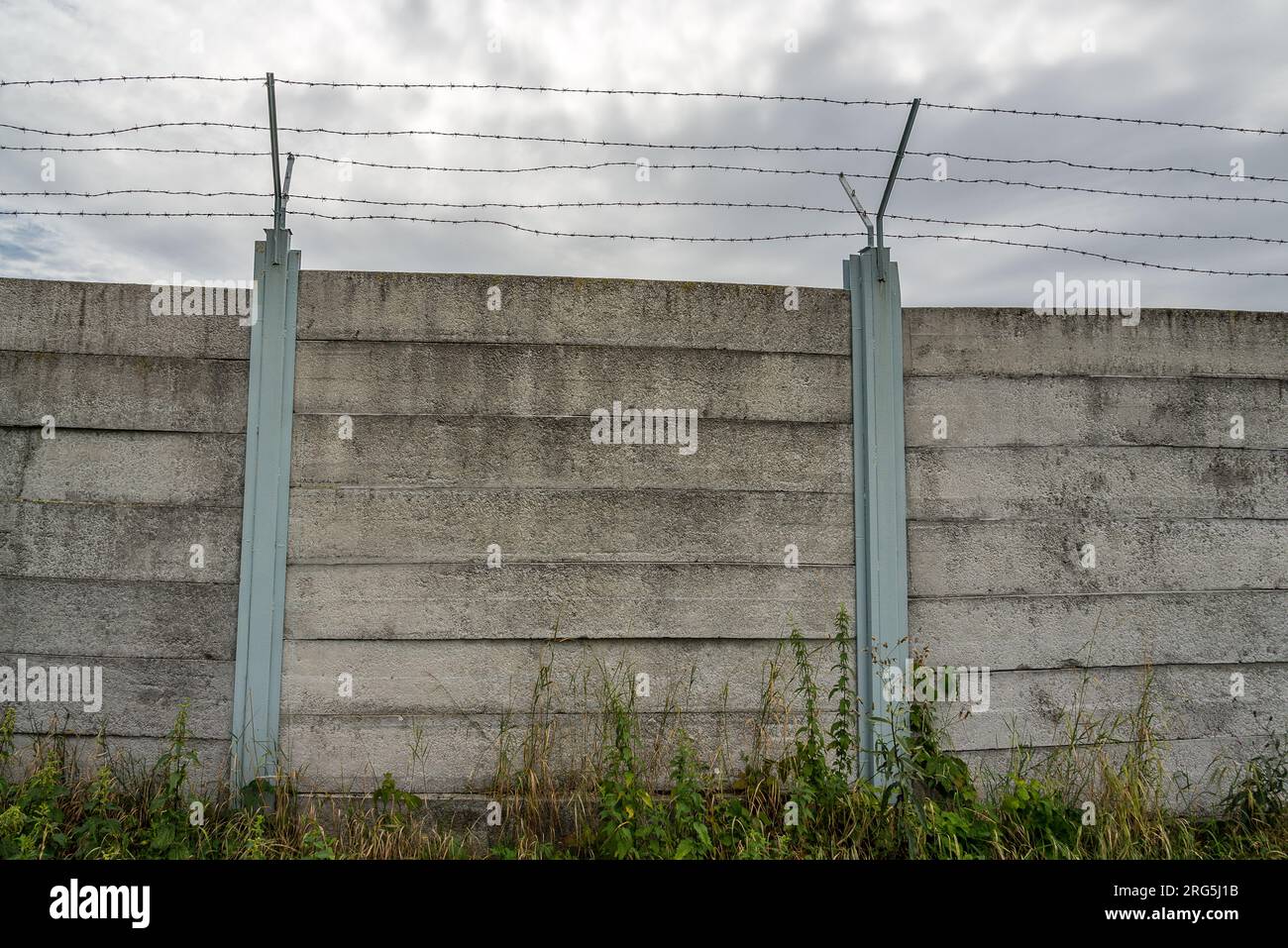 Barbed wire on the concrete fence Stock Photo - Alamy