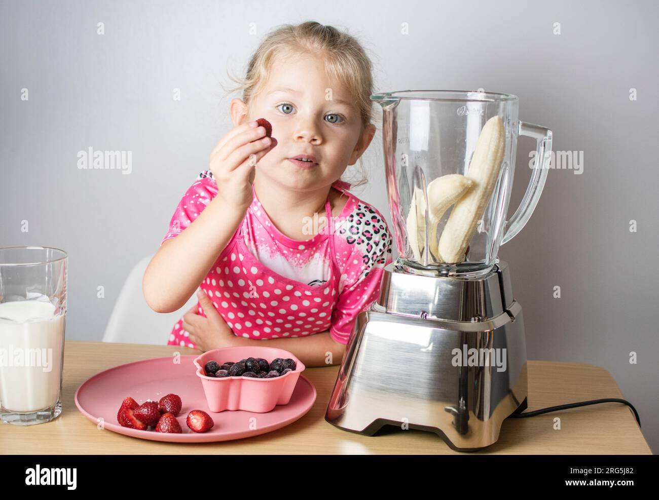 Cute Caucasian girl is cooking smoothie. Healthy eating kids. Learning ...