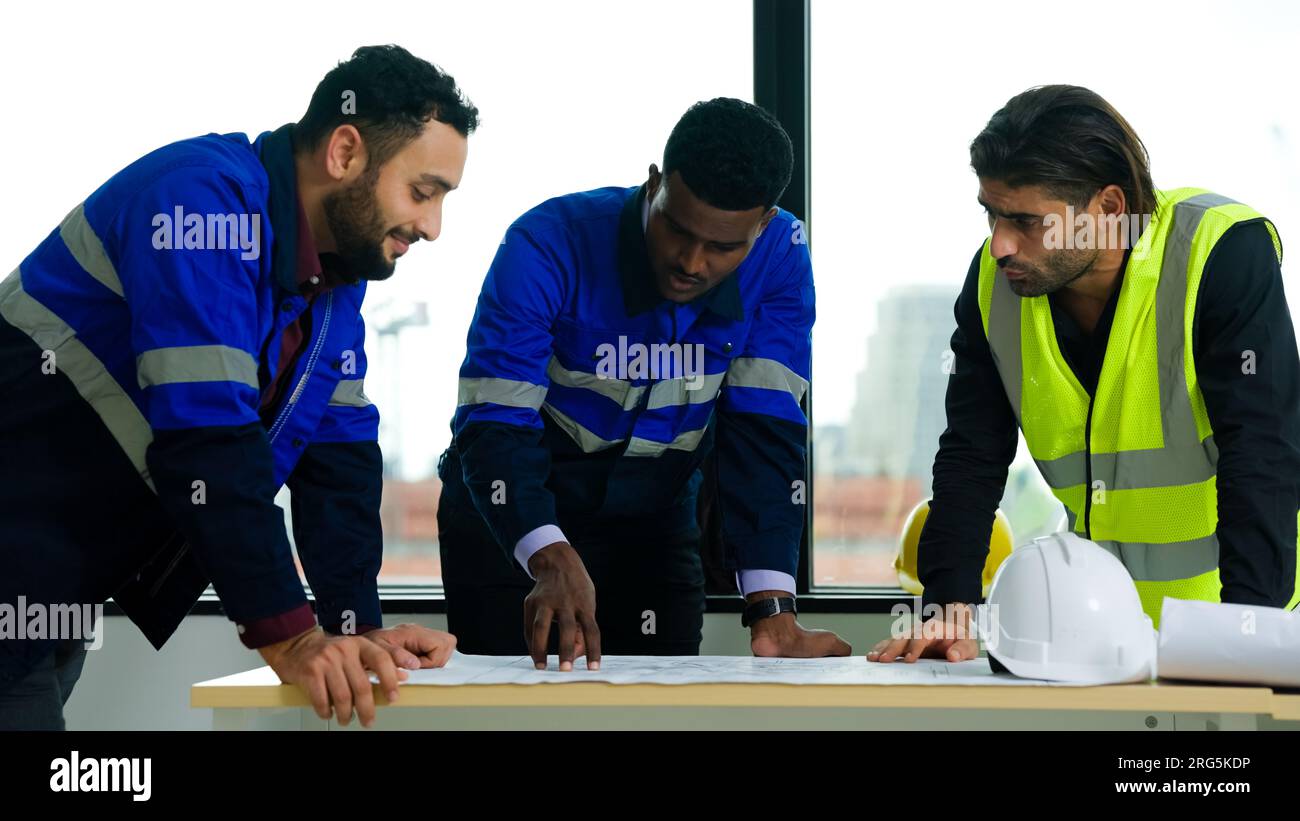 Construction engineers team using blueprint of project plan ...