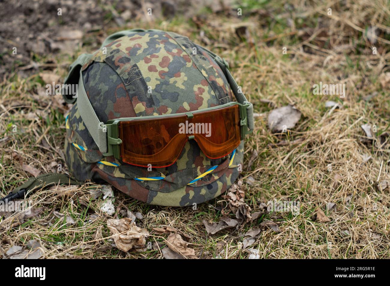 A military helmet with tactical goggles lies on the grass. Russian ...