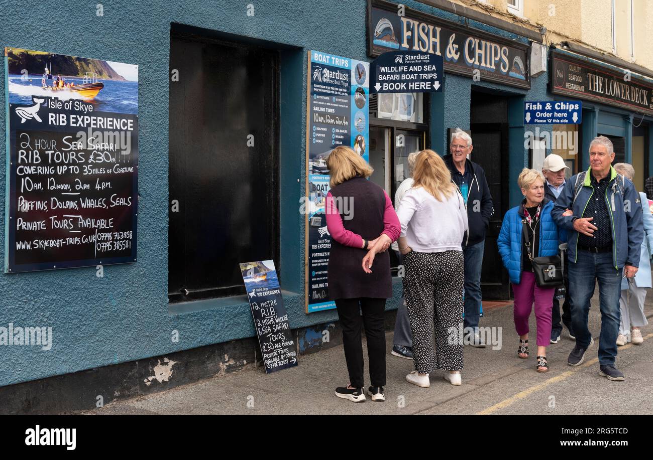 Portree Isle of Skye, Scotland, UK. 5 June 2023. Tourists reading tours ...