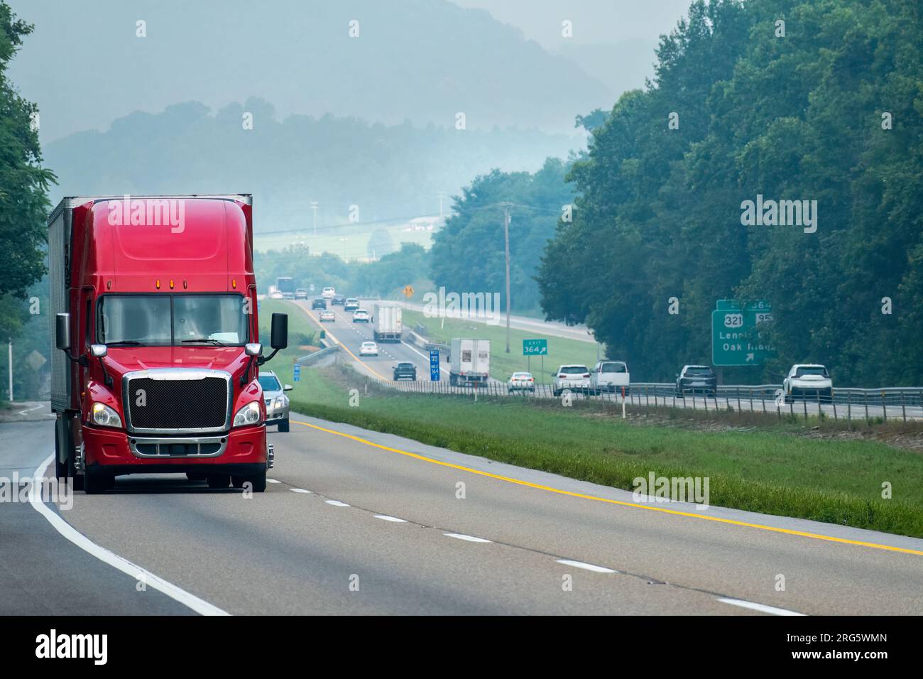 Horizontal shot of a big red eighteen wheeler traveling on an ...