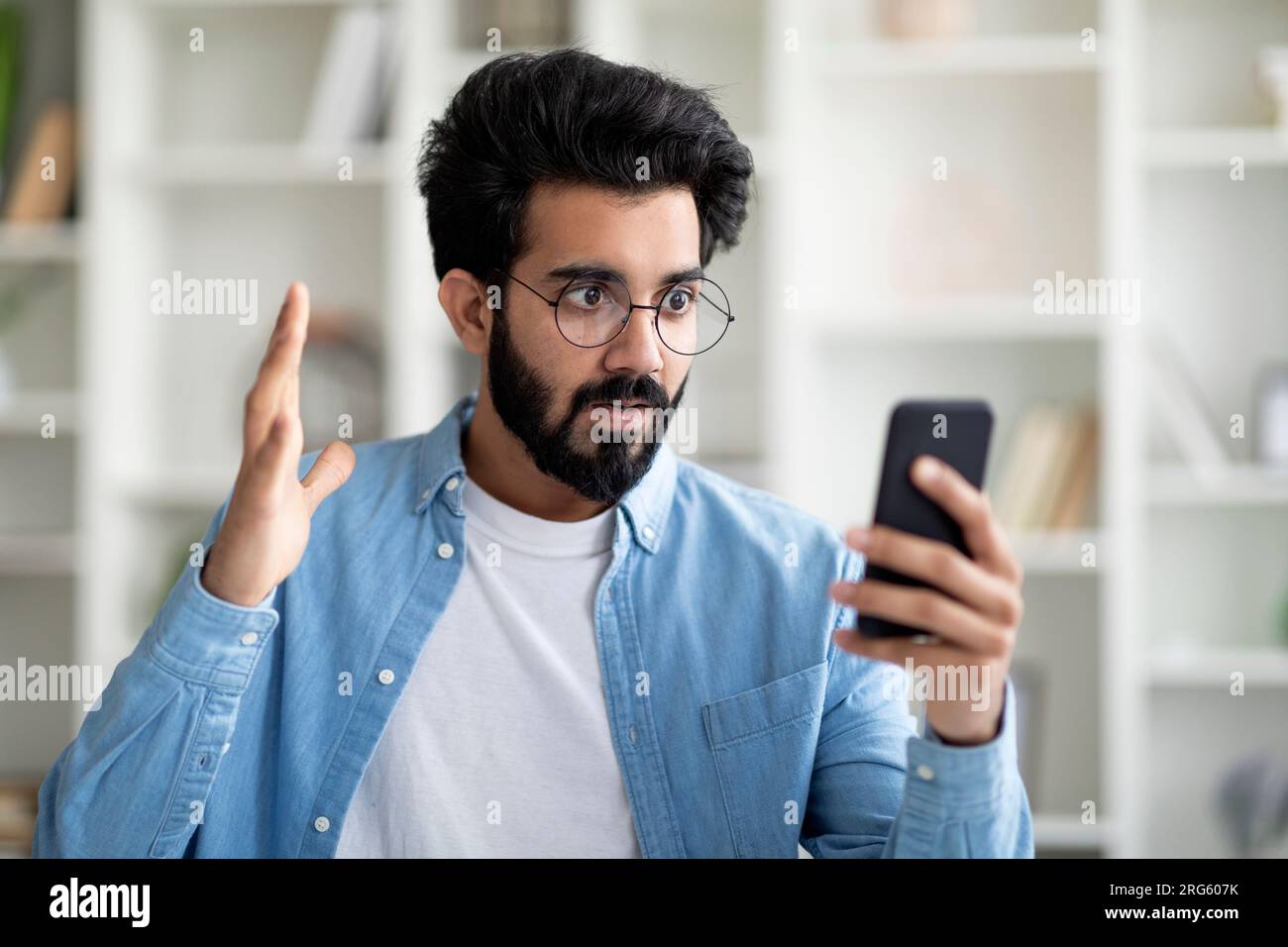 Bad News. Shocked Indian Man Looking At Smartphone In His Hand Stock ...