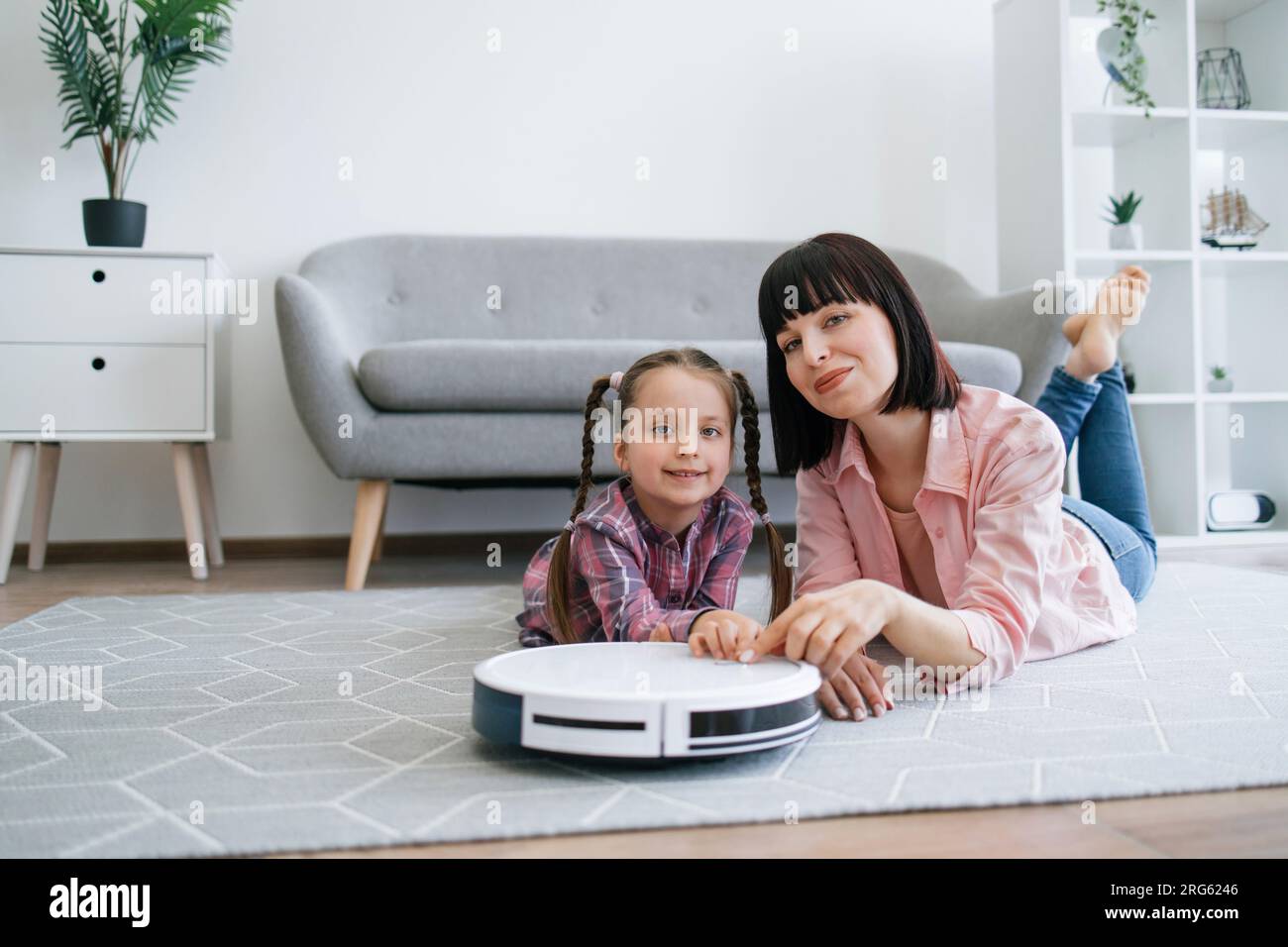 Beautiful ladies on floor posing near indoor cleaning robot Stock Photo ...