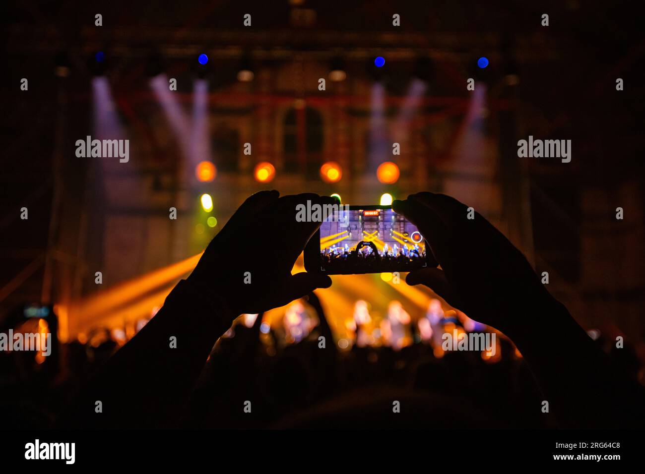 Hands holding phone and making photos on the concert. Concert ...