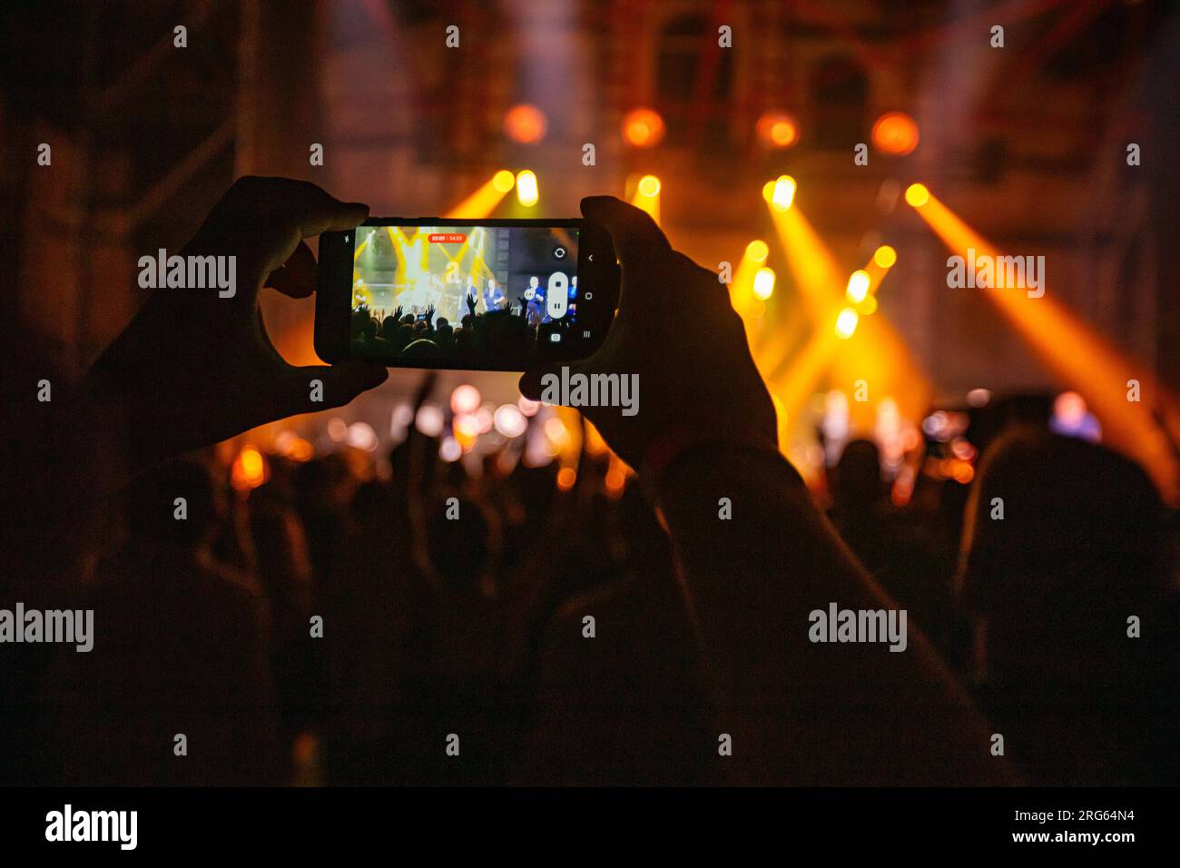 Hands holding phone and making photos on the concert. Concert ...