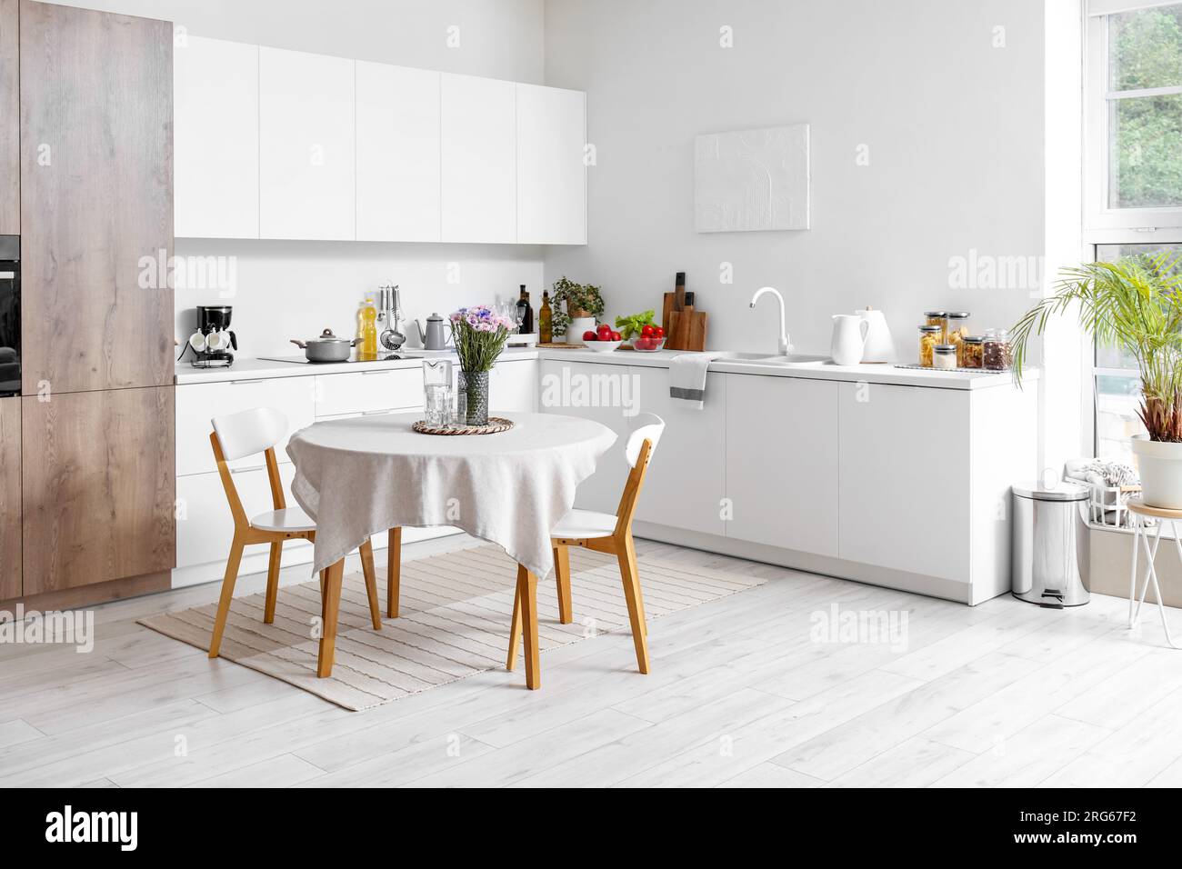 Interior of modern kitchen with flowers on dining table Stock Photo - Alamy