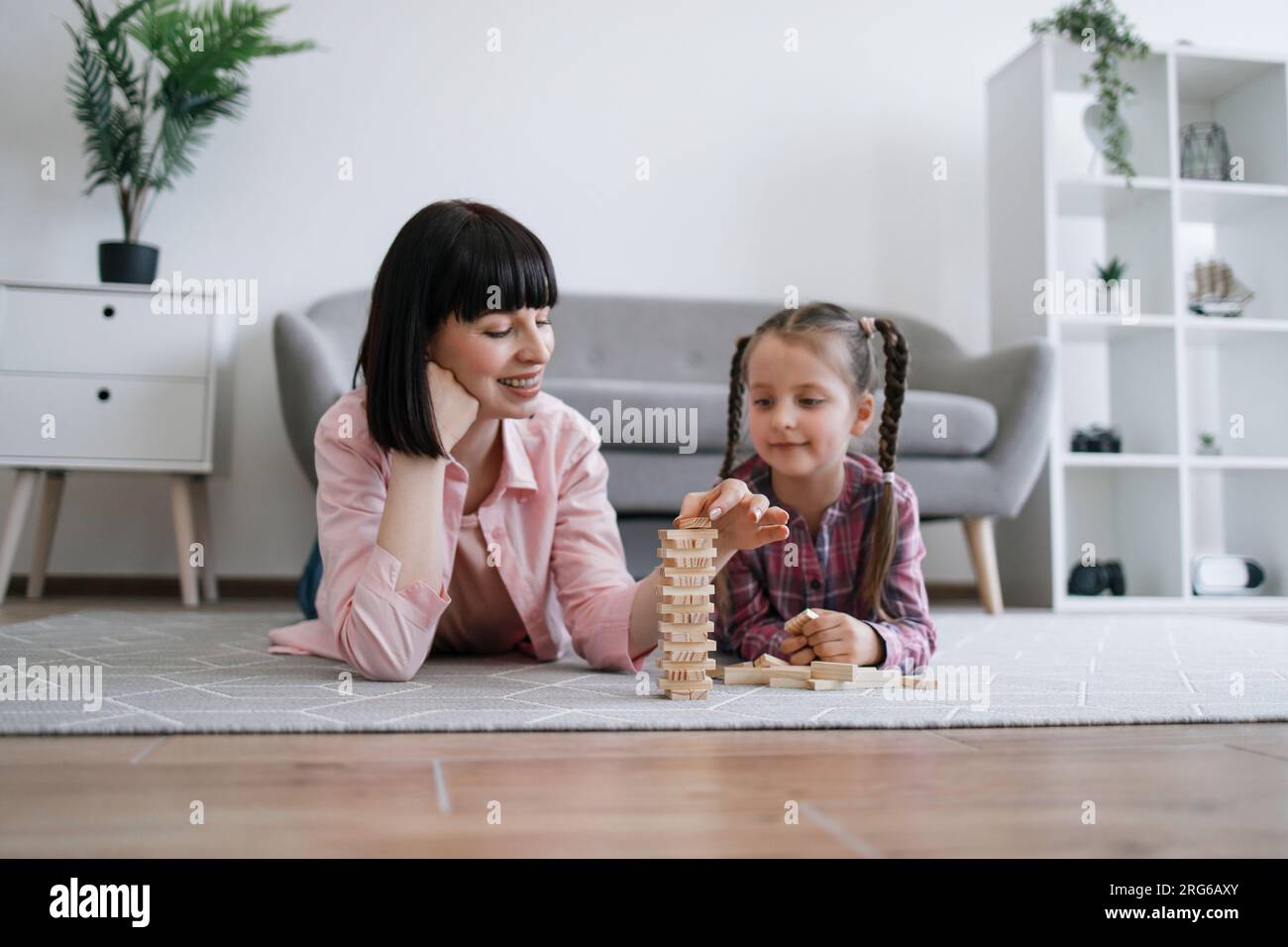 Parent with kid stacking blocks on wooden tower at home Stock Photo - Alamy