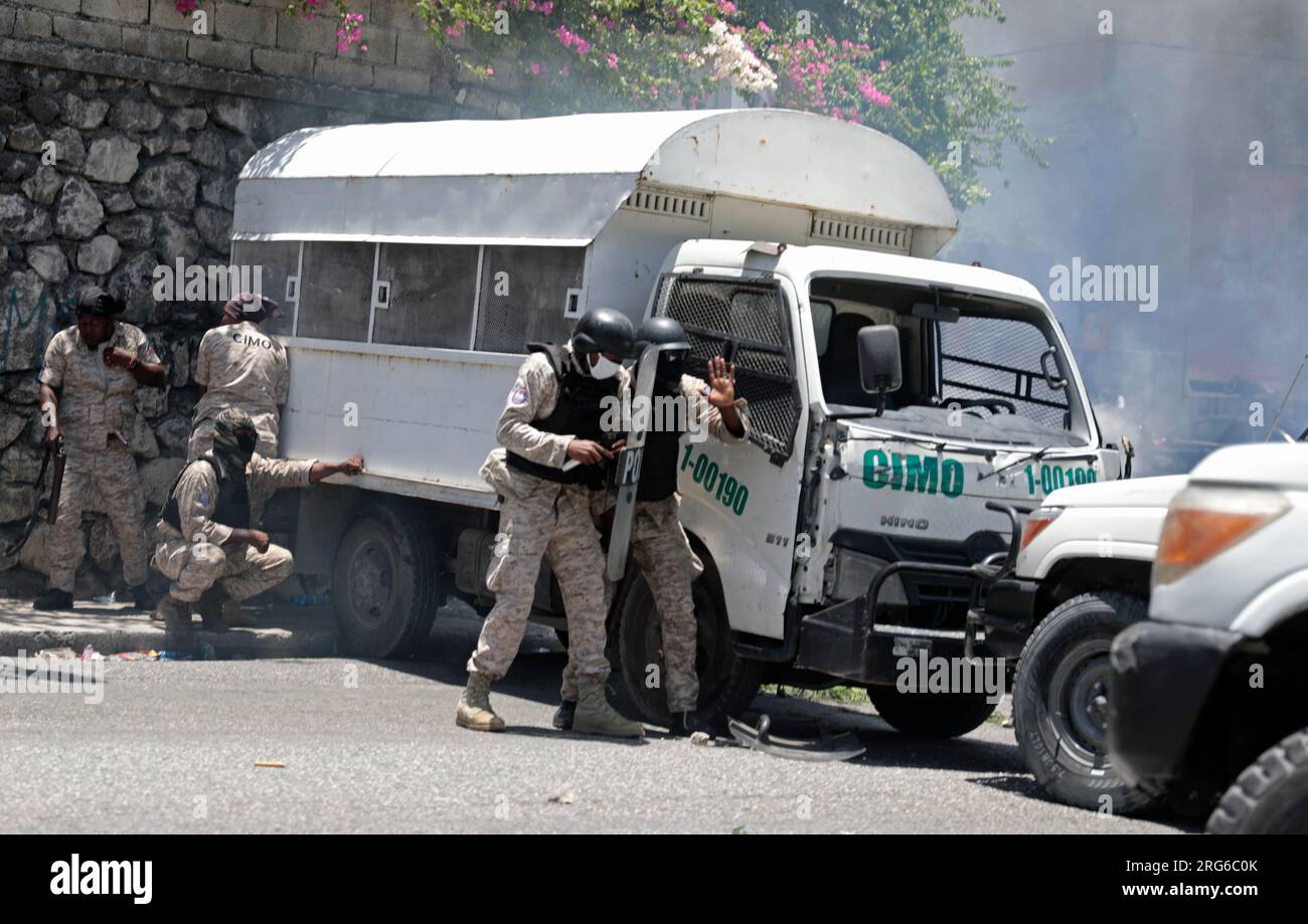 Police take cover from rocks thrown by demonstrators protesting ...