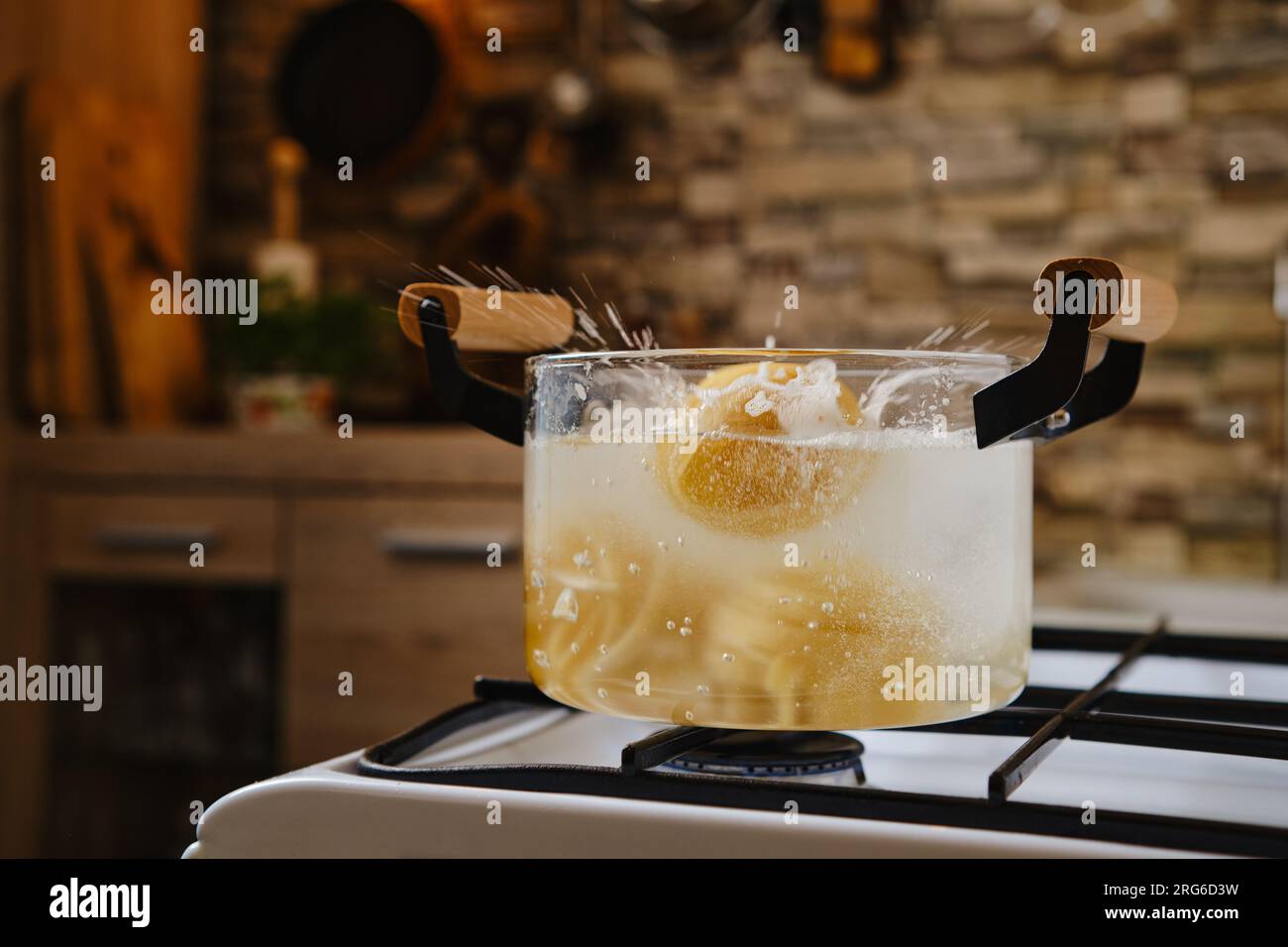 Drop fettuccine pasta into boiling water in a saucepan Stock Photo - Alamy