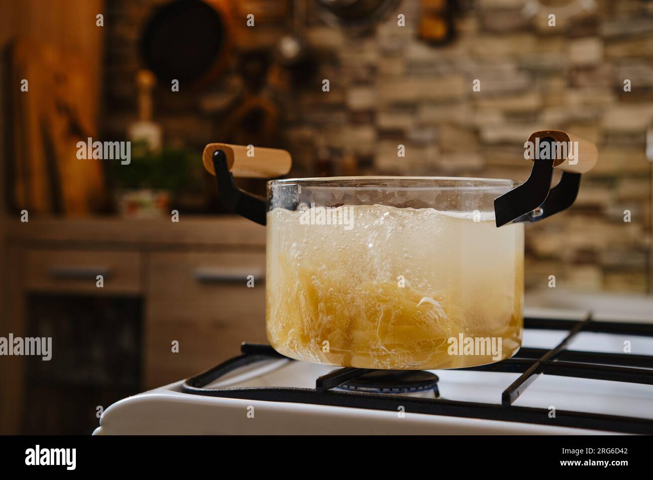 Cooking fettuccine pasta into boiling water in a transparent glass ...