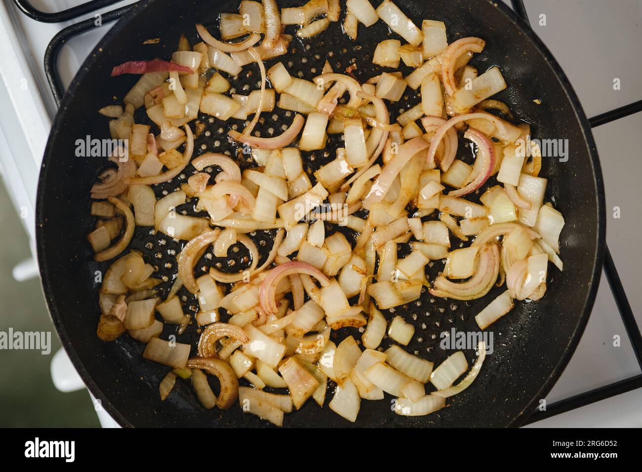Frying shallots onion in a pan on a gas stove Stock Photo - Alamy