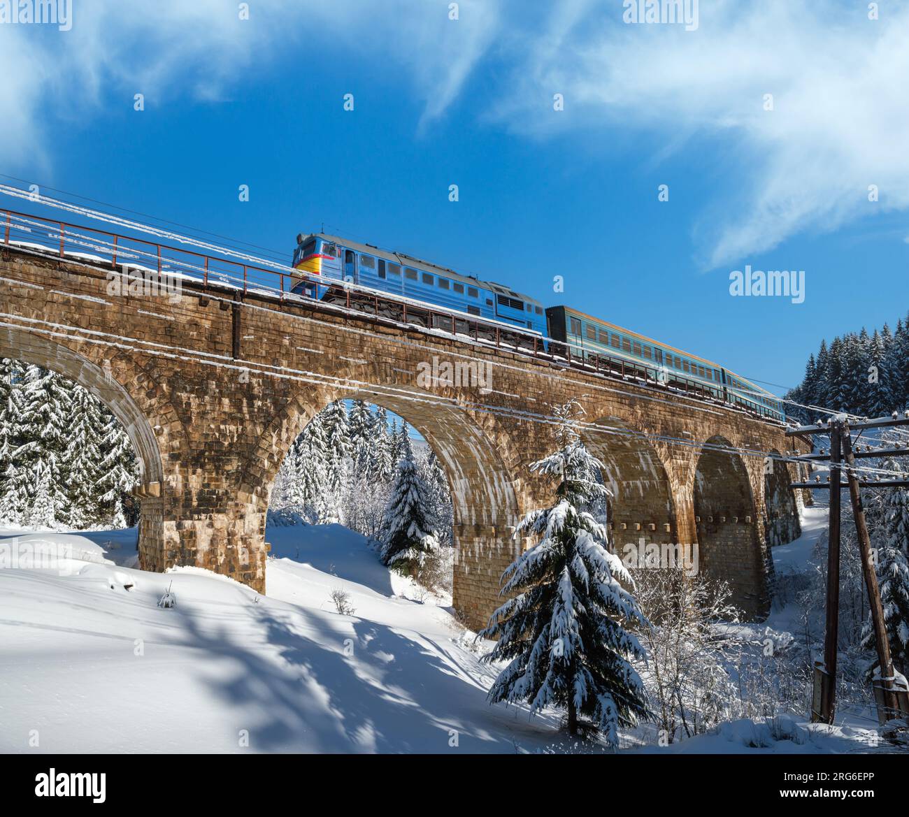 Stone viaduct (arch bridge) on railway through mountain snowy fir ...