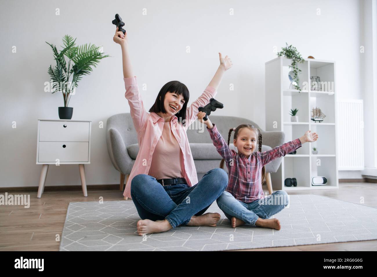 Happy family gamers with joysticks raising hands in success Stock Photo ...