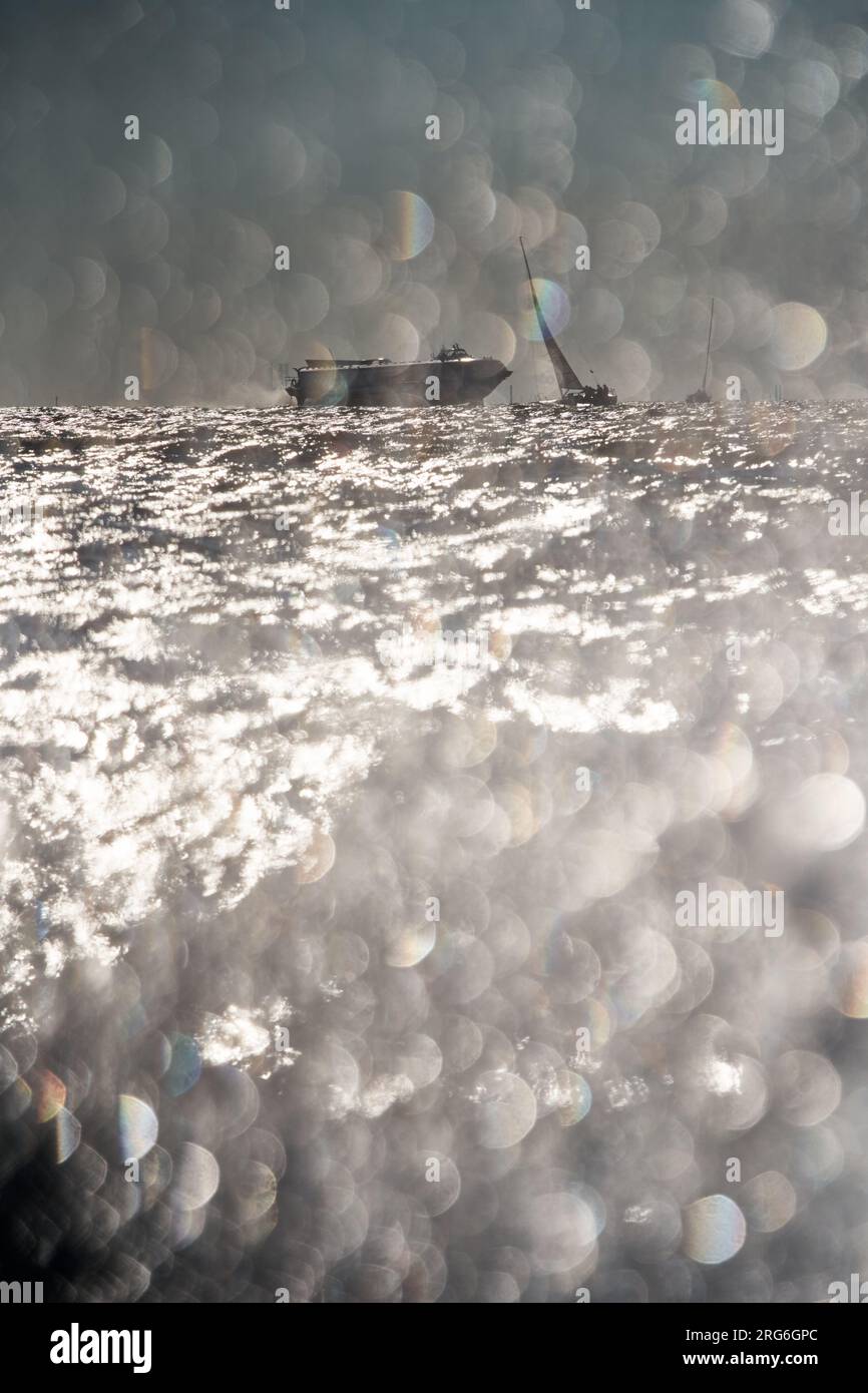 The view through the spray of how the sailboat is heeling at sunset ...