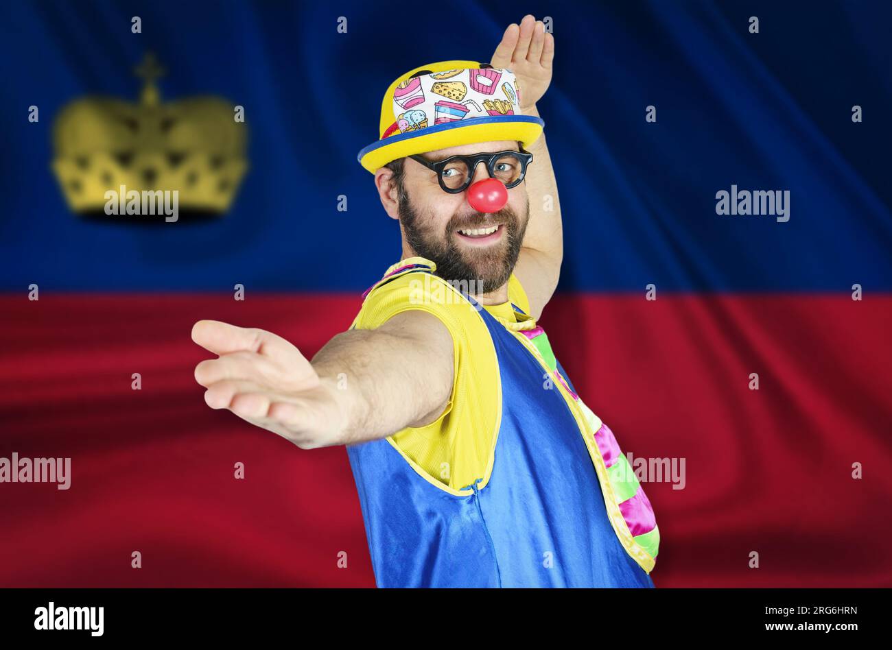 A cheerful clown stands in a welcoming pose against the background of ...