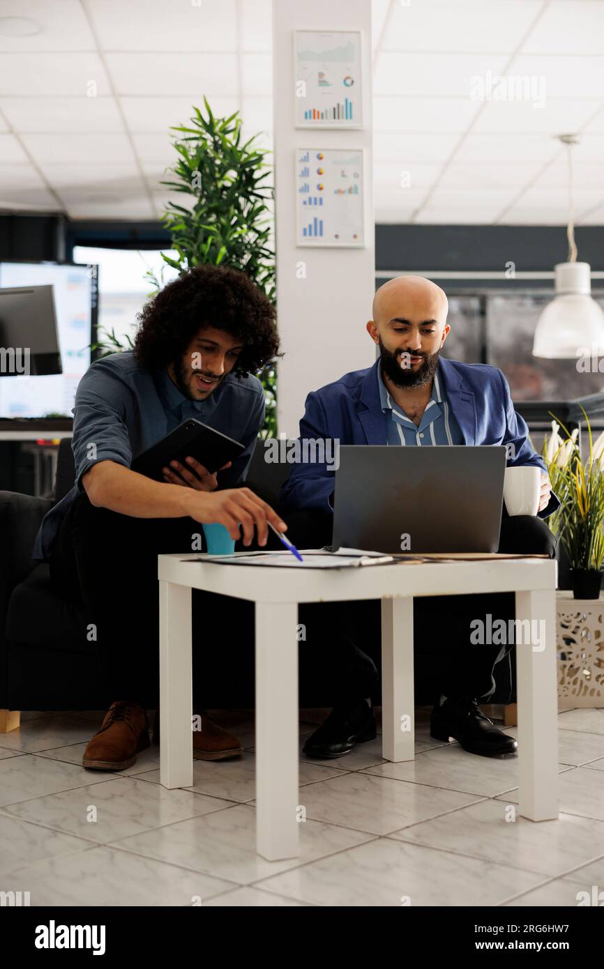 Arab coworkers analyzing financial data and creating presentation on ...