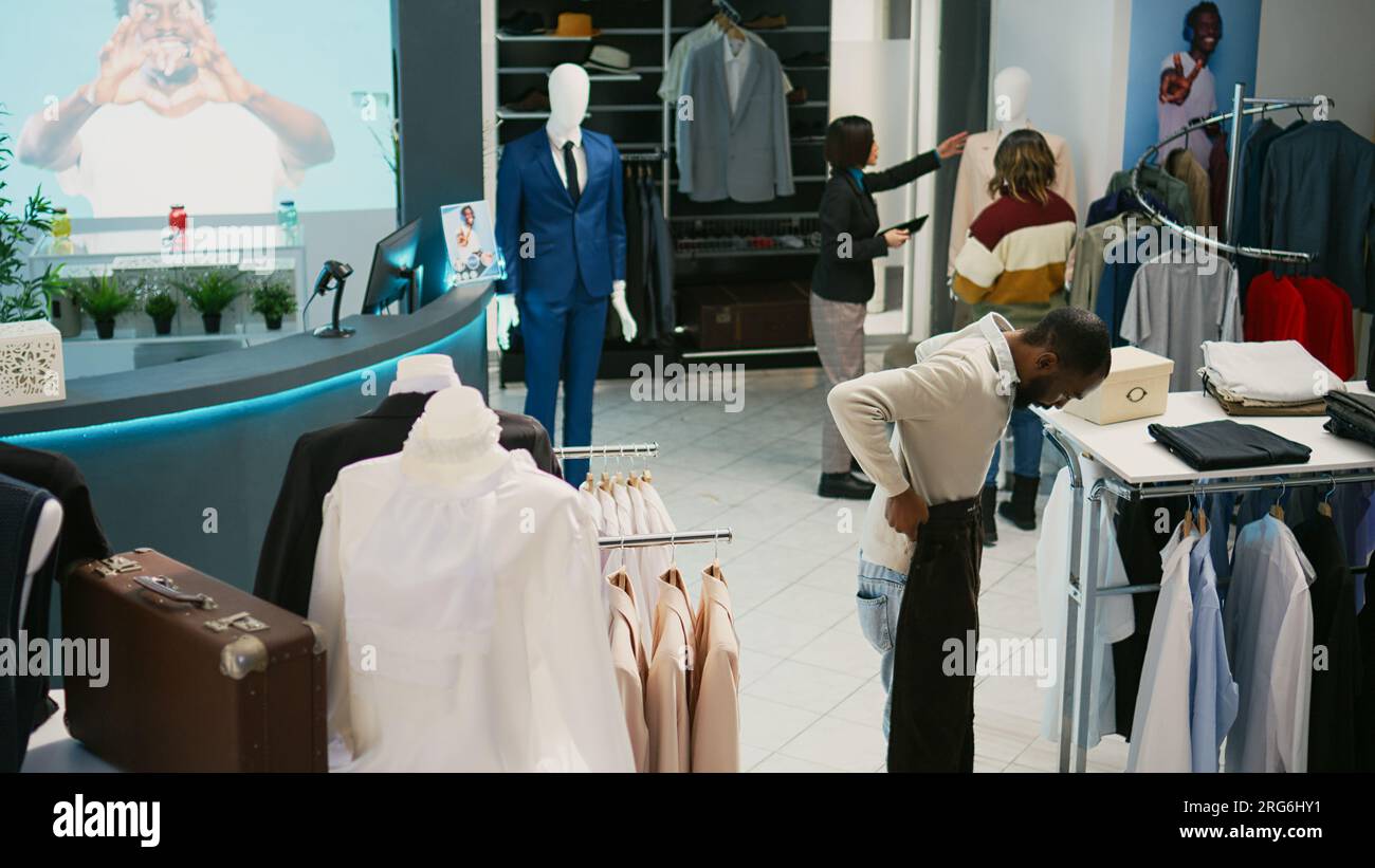 Multiethnic group of people looking at trendy clothes in retail store ...