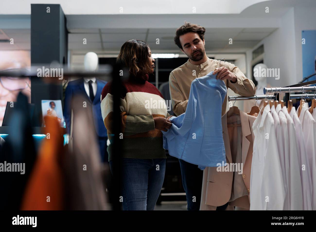 Clothing store customer getting fashion recommendation from consultant ...