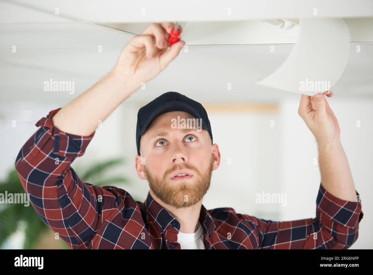 man standing on a ladder working on ceiling Stock Photo - Alamy