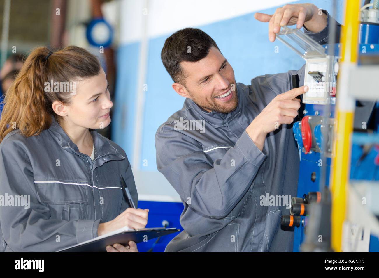 workers adjusting dial on machine Stock Photo - Alamy