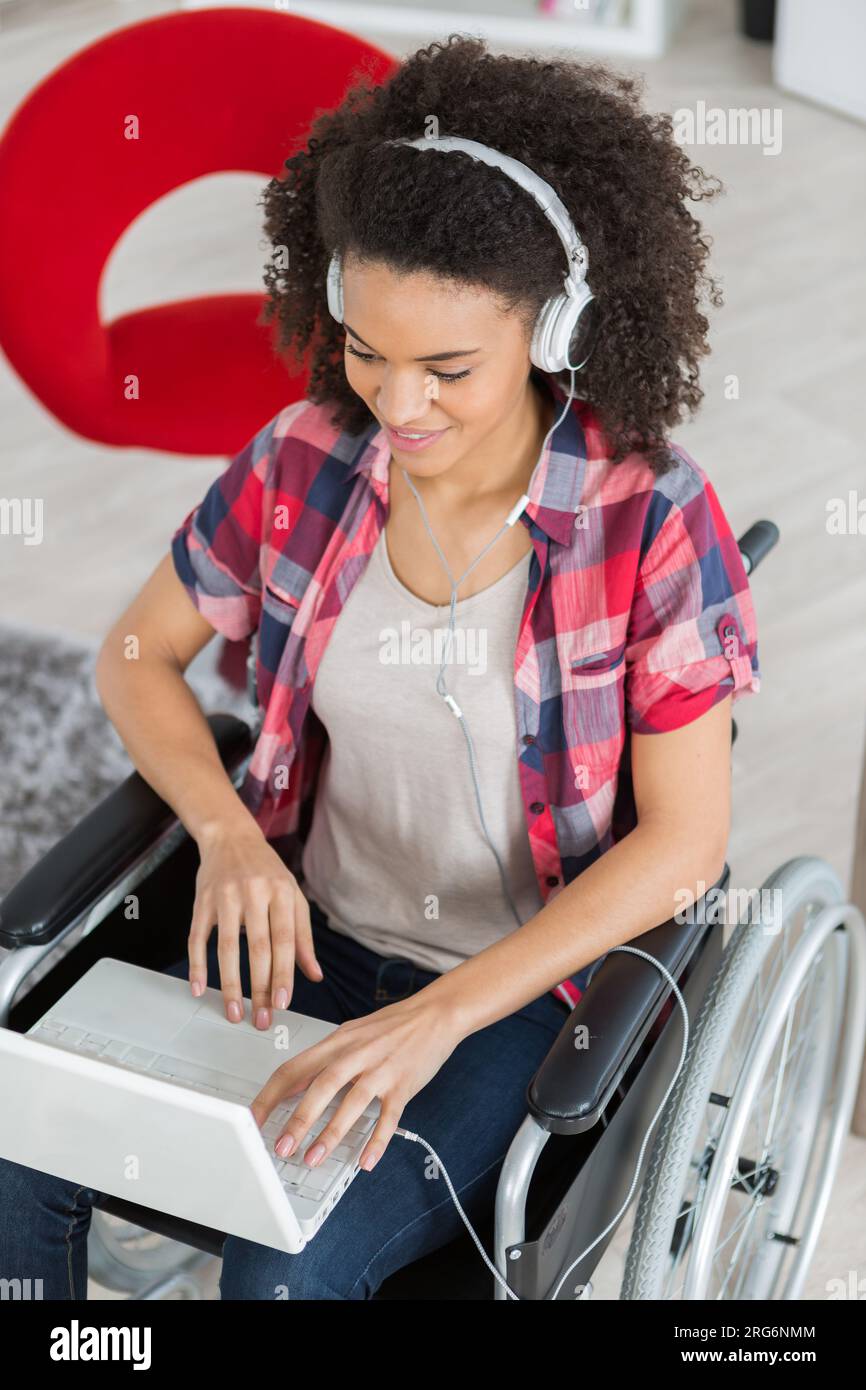 disabled lady using notepad computer and wearing headphones Stock Photo ...