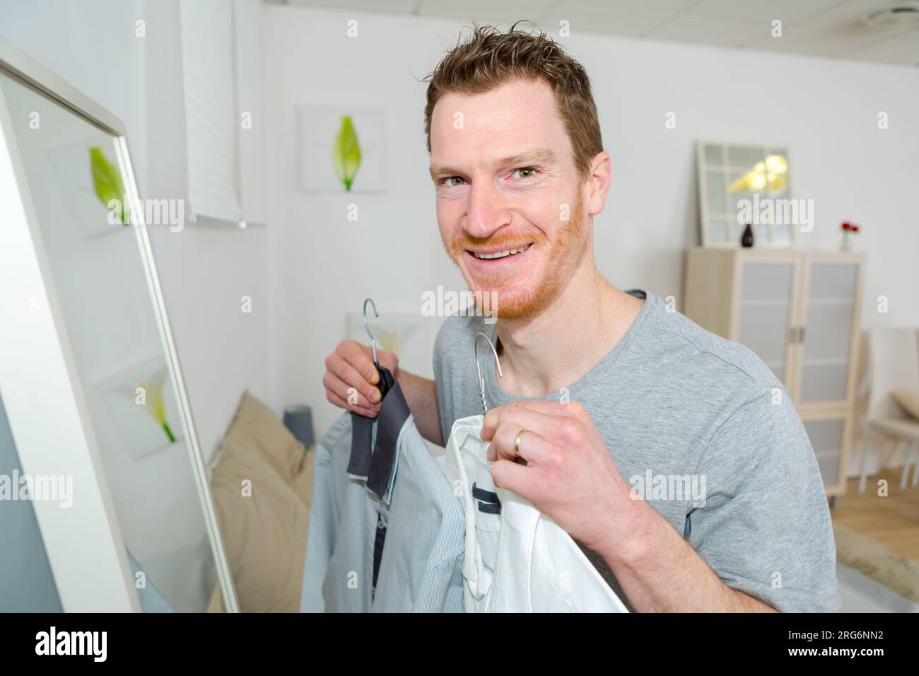 young man trying to decide what to wear Stock Photo - Alamy