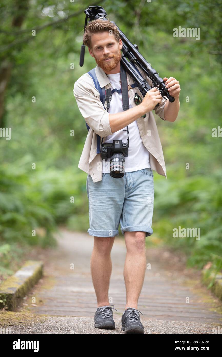 a man carrying camera and tripod Stock Photo - Alamy