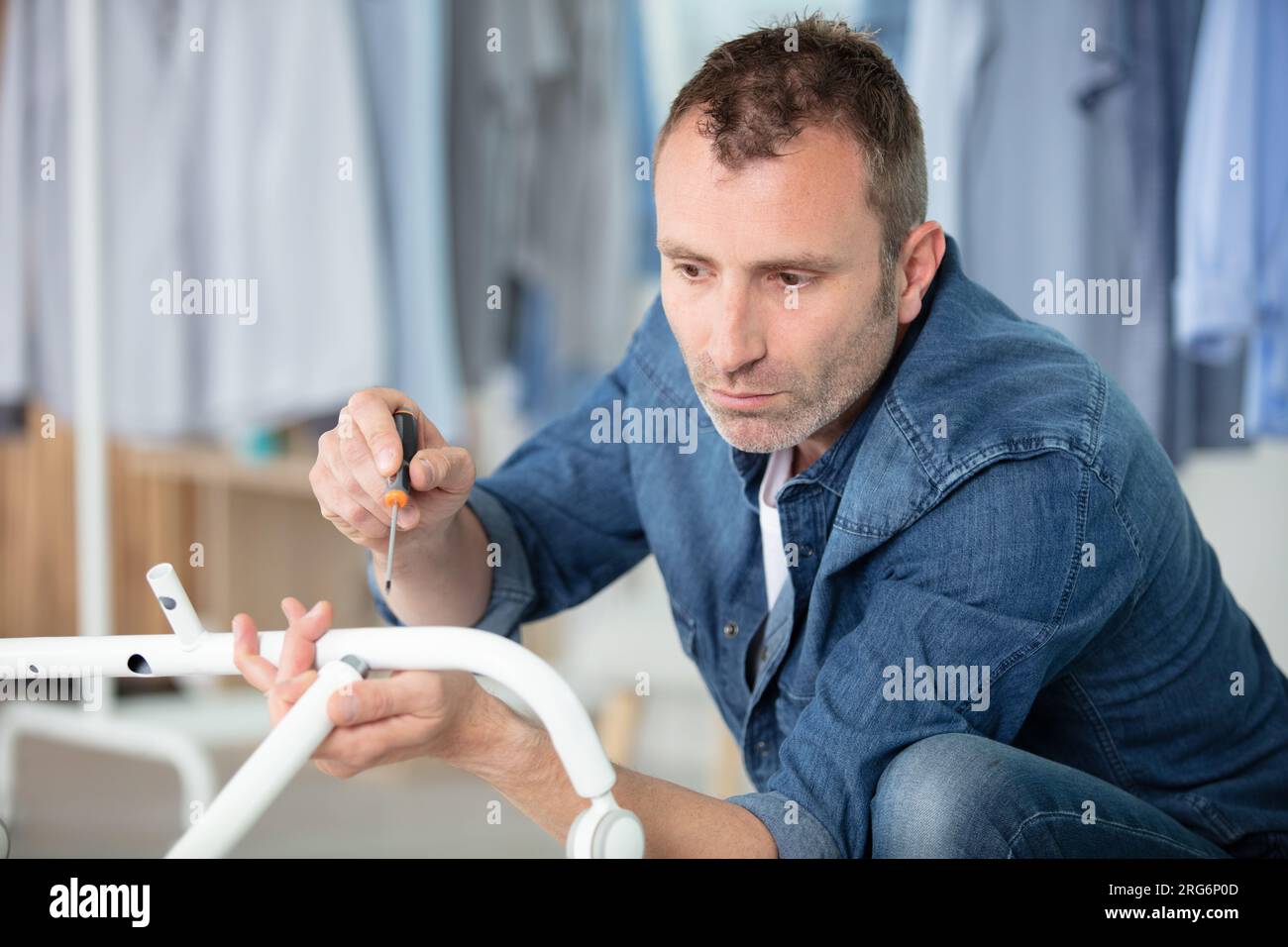 man assembling a metal furniture with allen-key Stock Photo - Alamy