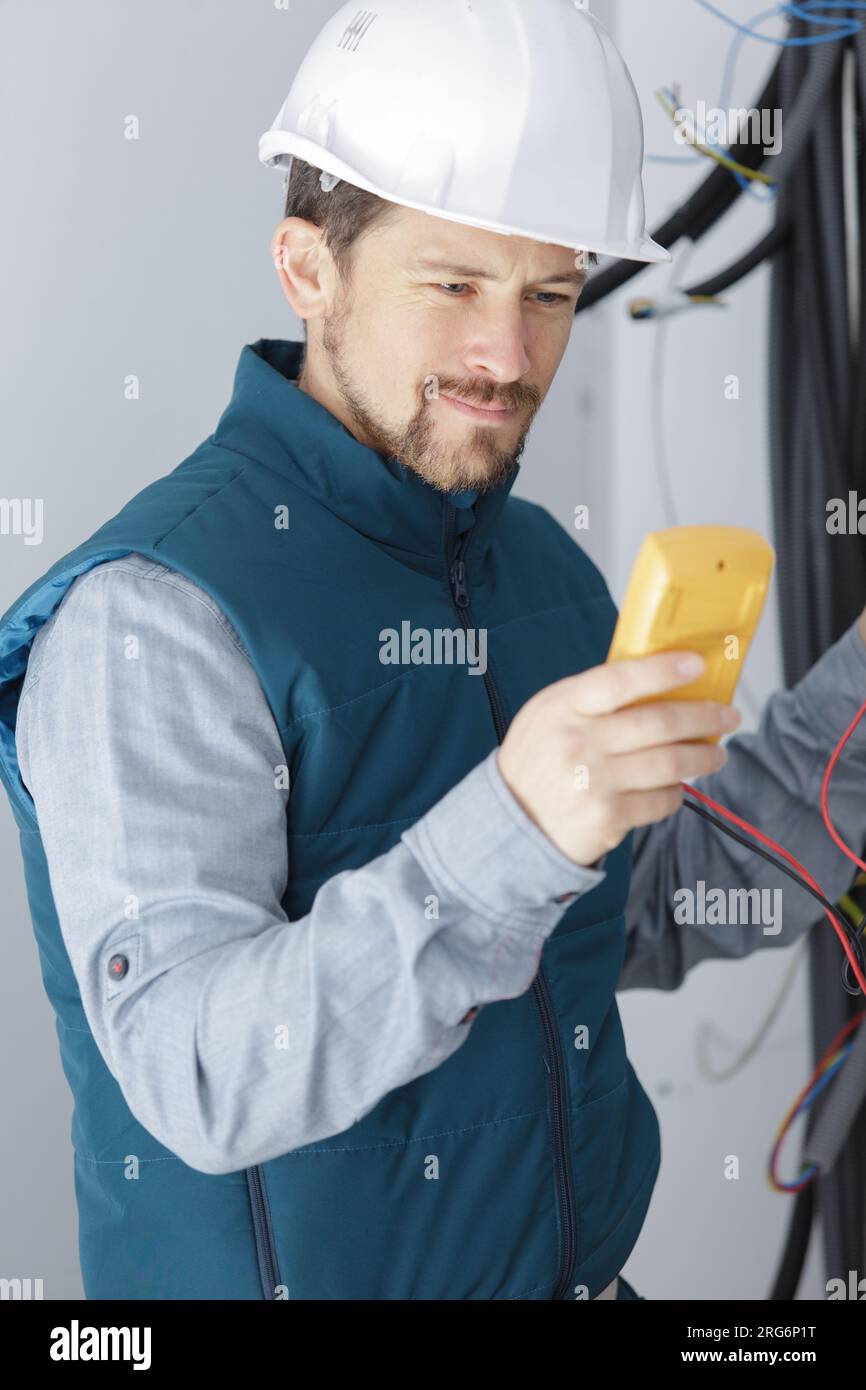 electrician measuring voltage in distribution board Stock Photo - Alamy