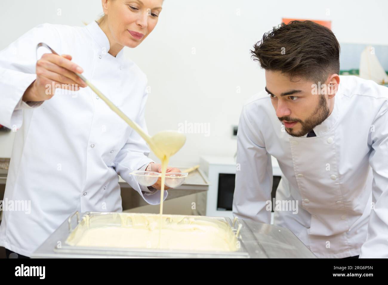 chocolate artisan scooping white melted chocolate Stock Photo - Alamy