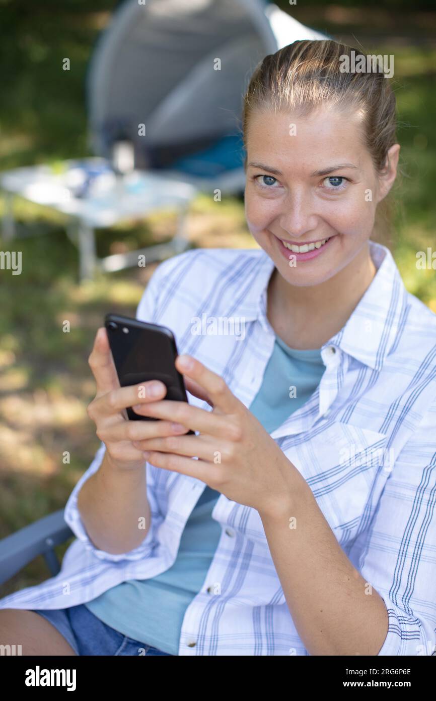 camping woman using mobile phone Stock Photo - Alamy