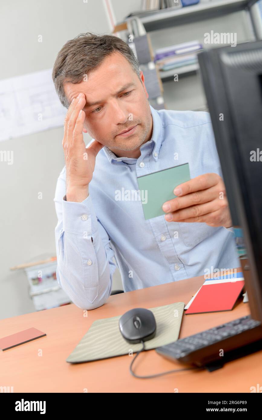 Confused man at his desk Stock Photo - Alamy