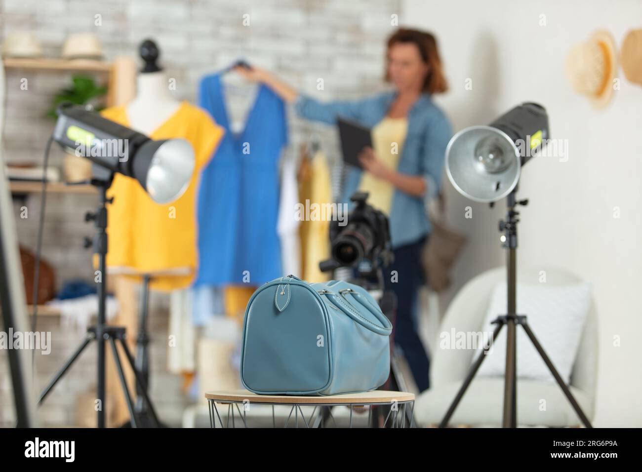 stylist choosing clothes for model to wear on studio photoshoot Stock ...