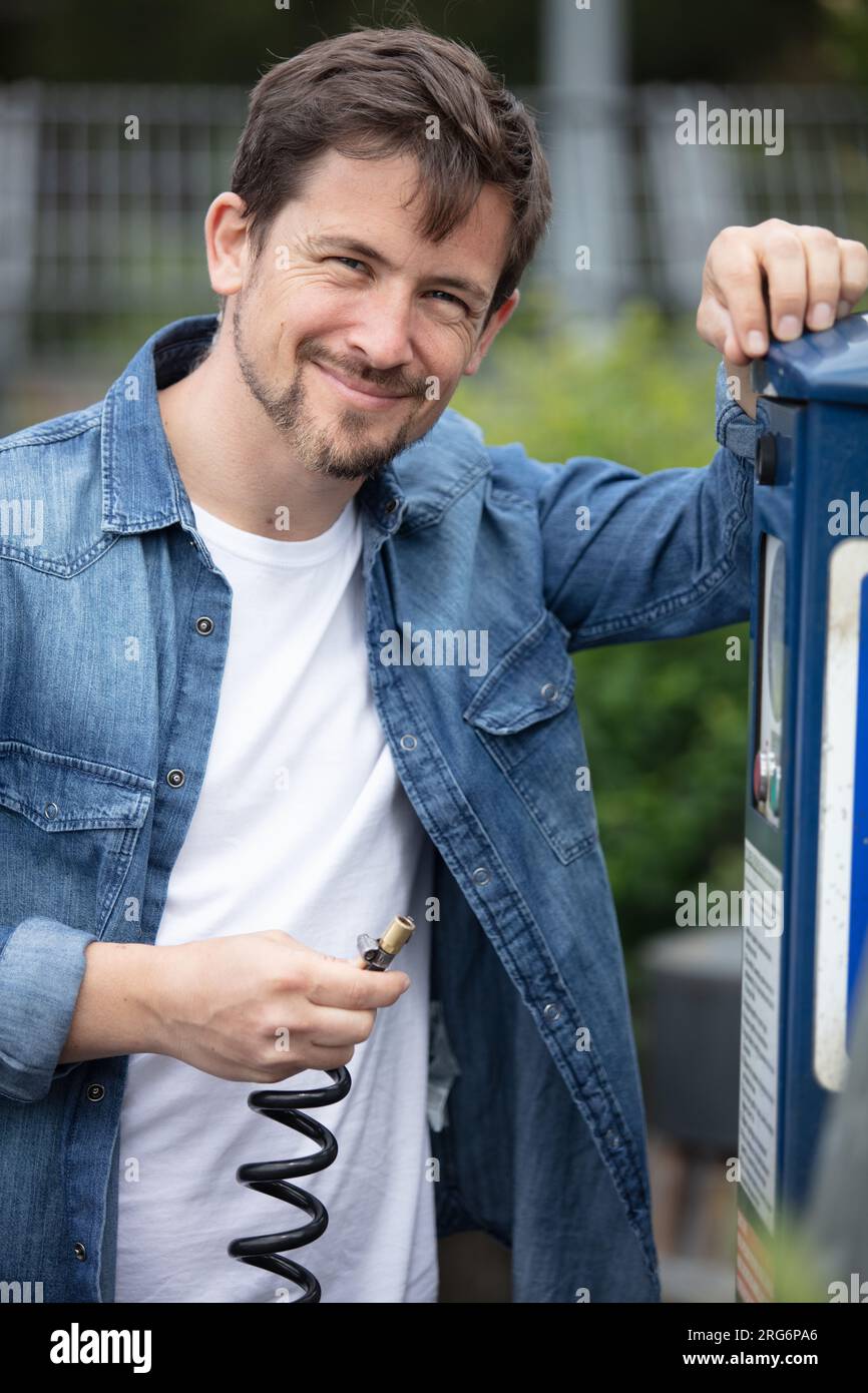 smiling man is inflating a tire Stock Photo - Alamy