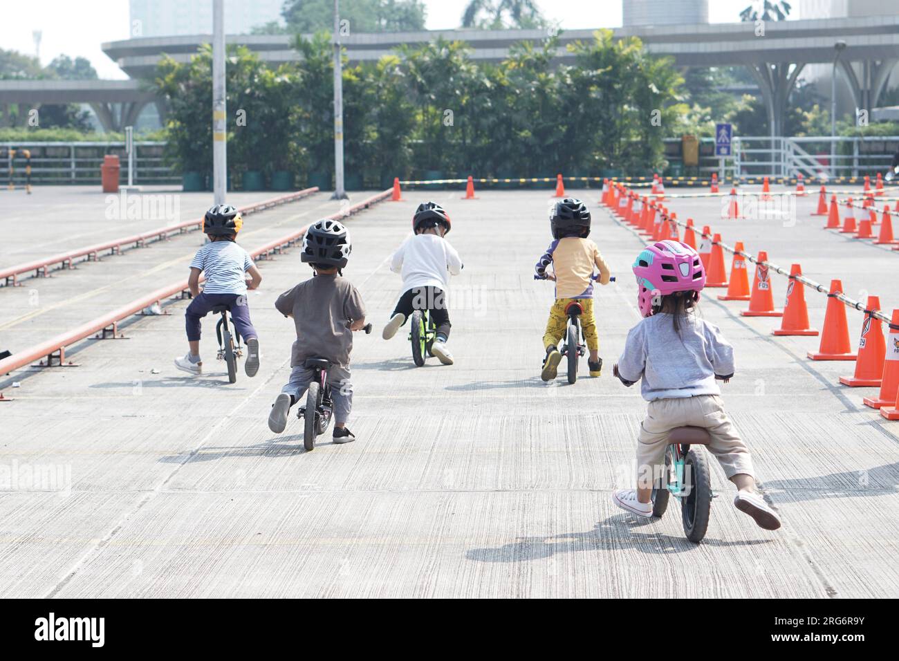 kids from 2-5 years old races on balance bike in a parking area with ...