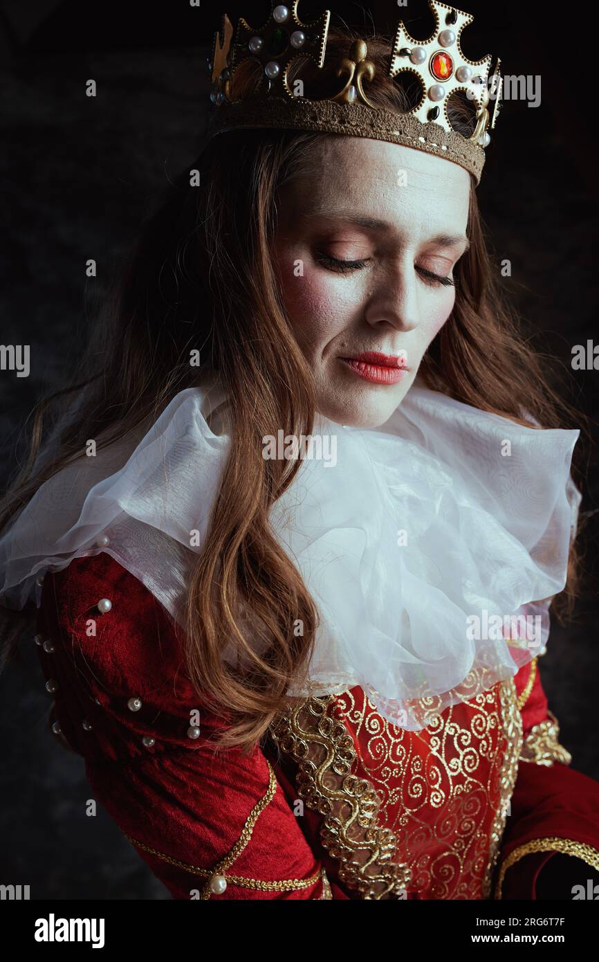 medieval queen in red dress with white collar and crown on dark gray ...