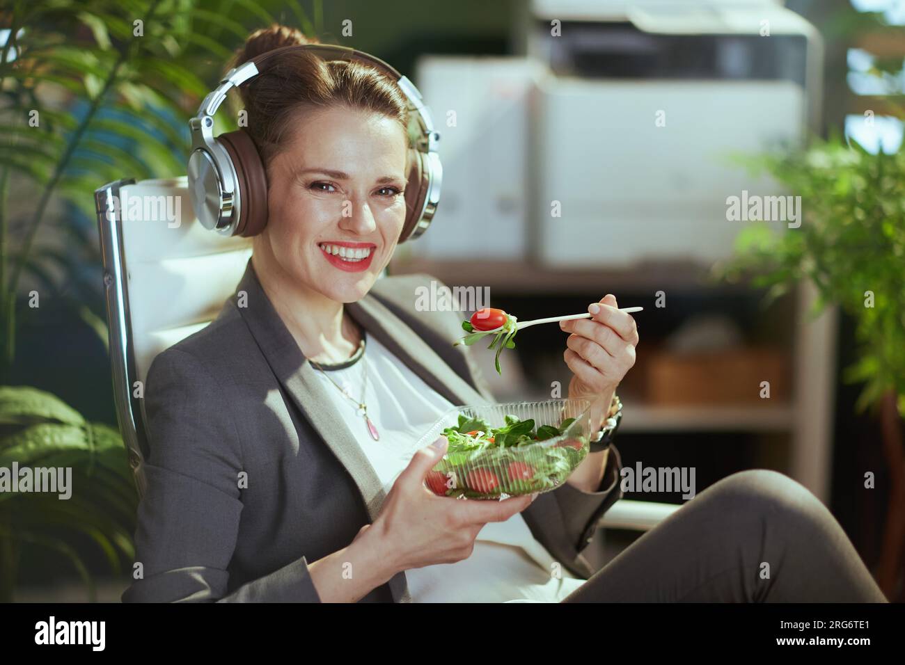 Sustainable workplace. smiling modern bookkeeper woman in a grey ...