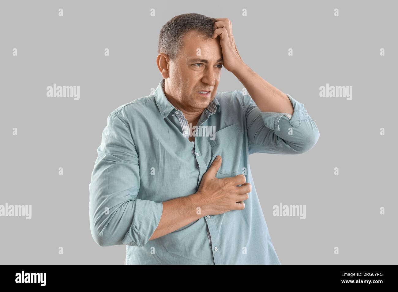 Mature man having panic attack on light background Stock Photo - Alamy